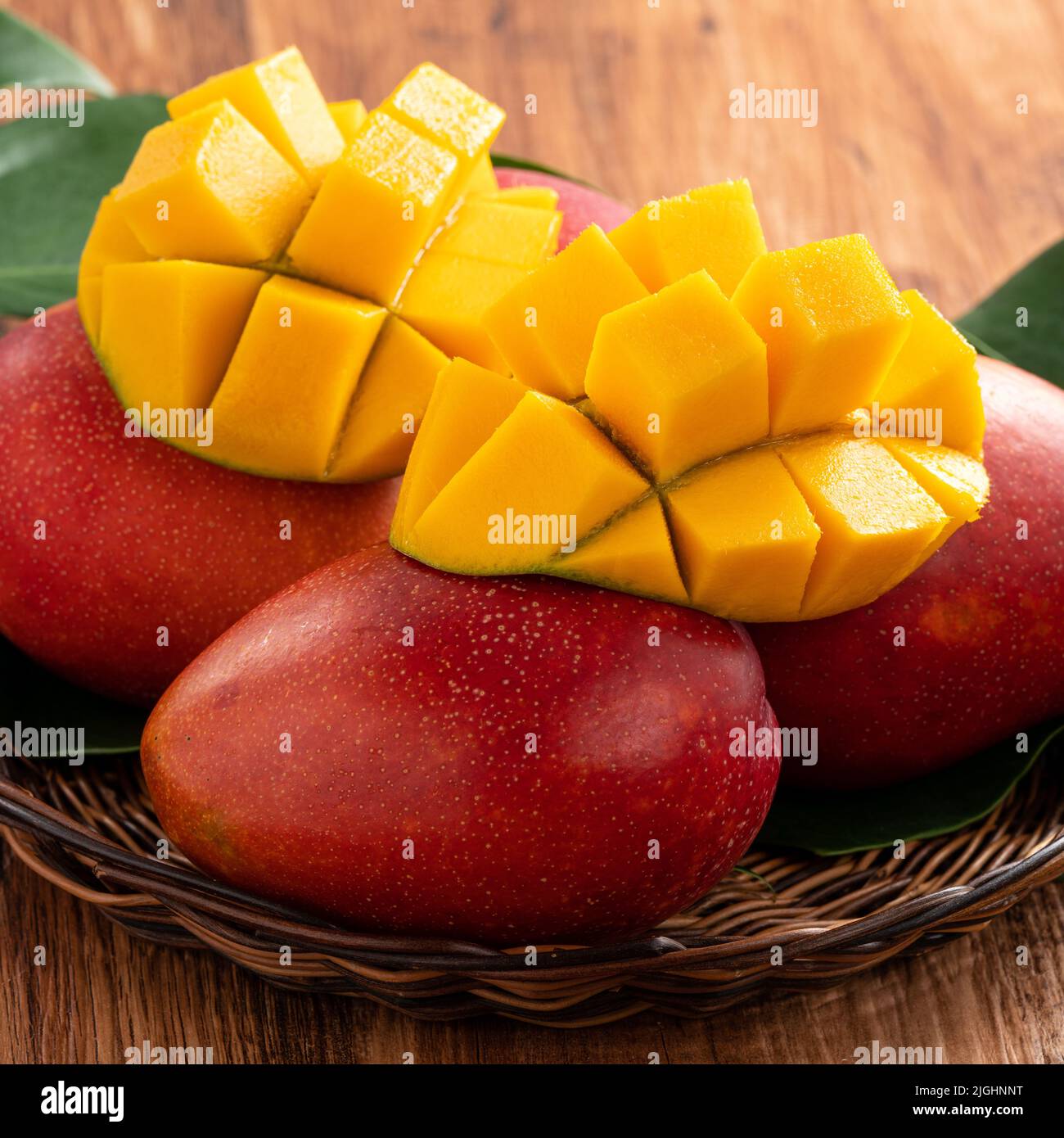 Mango. Close up of fresh ripe mango fruit with leaves over dark wooden ...