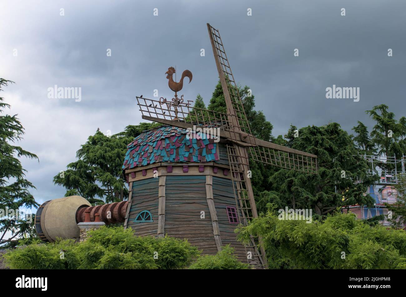 Windmill surrounded by trees Disneyland Paris with cloudy sky ...
