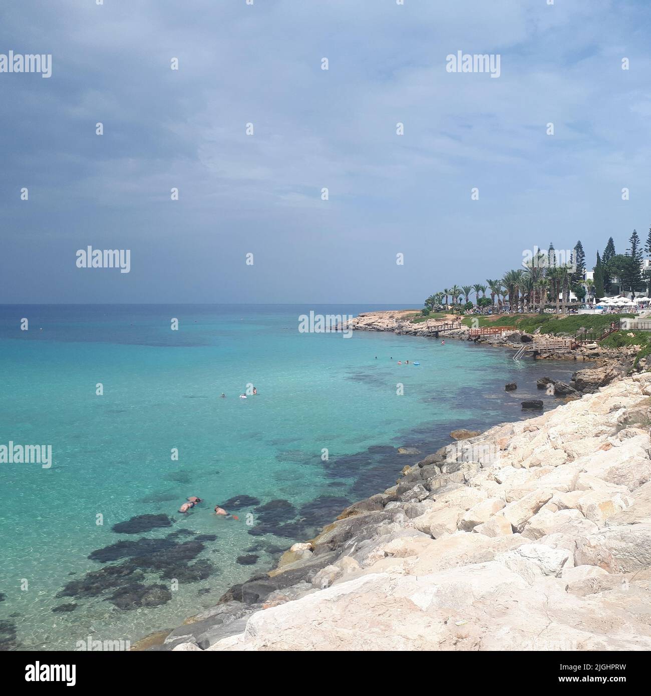 Paphos coast with crystal blue waters rocks and trees with a rolling ...