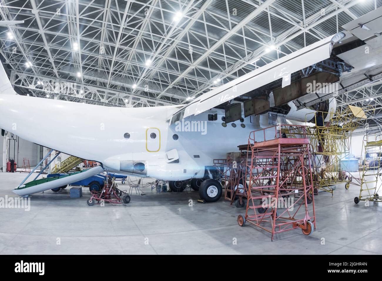 White transport airplane in the hangar. Aircraft under maintenance ...