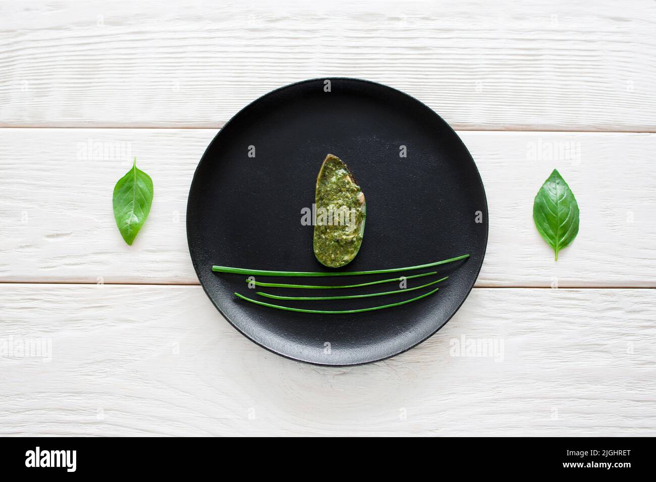 Stuffed mussel on black plate, white background Stock Photo - Alamy