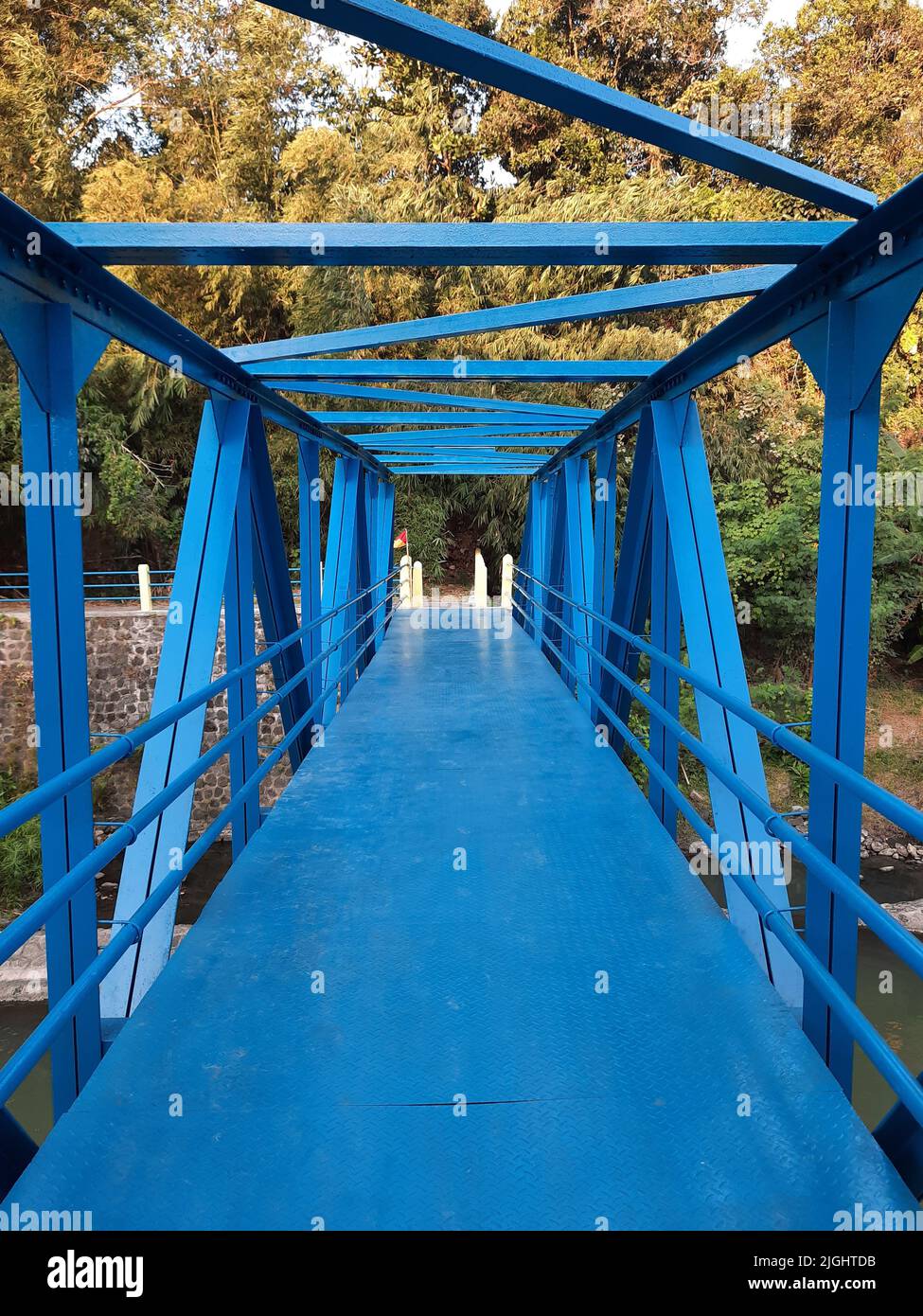 Vertical view through a blue bridge for pedistrian and bikes over a ...