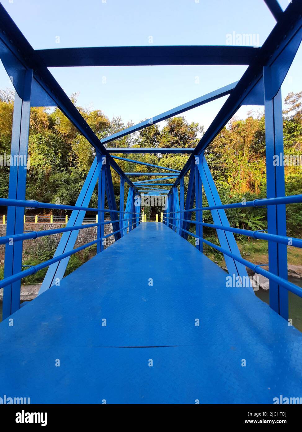 Vertical view through a blue bridge for pedistrian and bikes over a ...