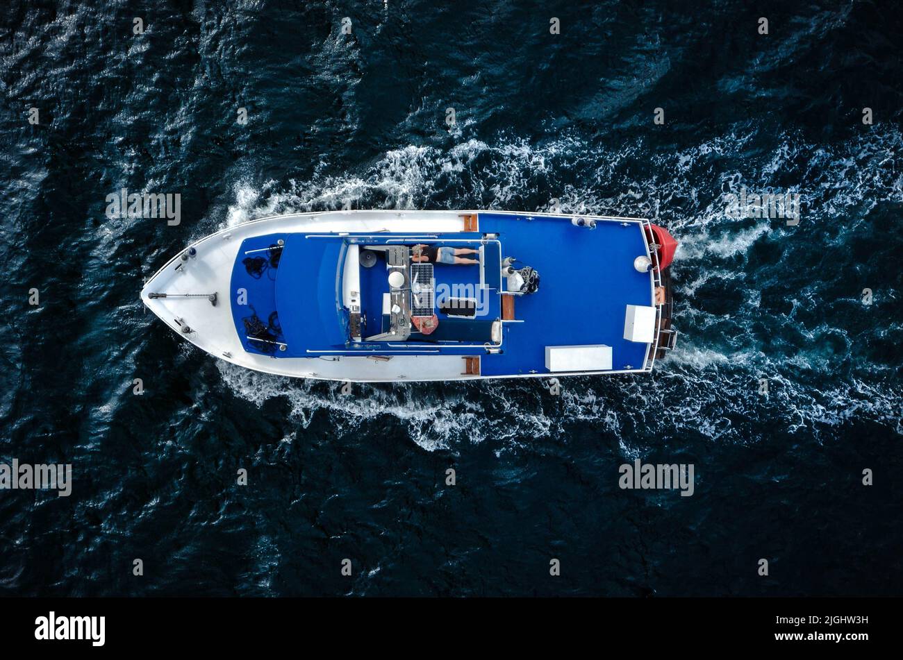 A top view of a motorized boat sailing through water leaving a foamy ... A top view of a motorized boat sailing through water leaving a foamy ...