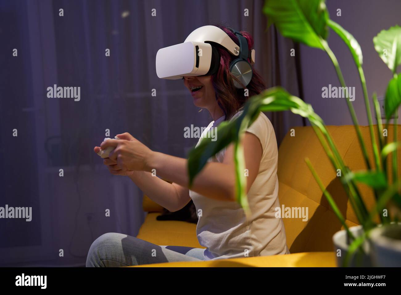 Woman with virtual reality headset and joystic is playing game. Concept ...