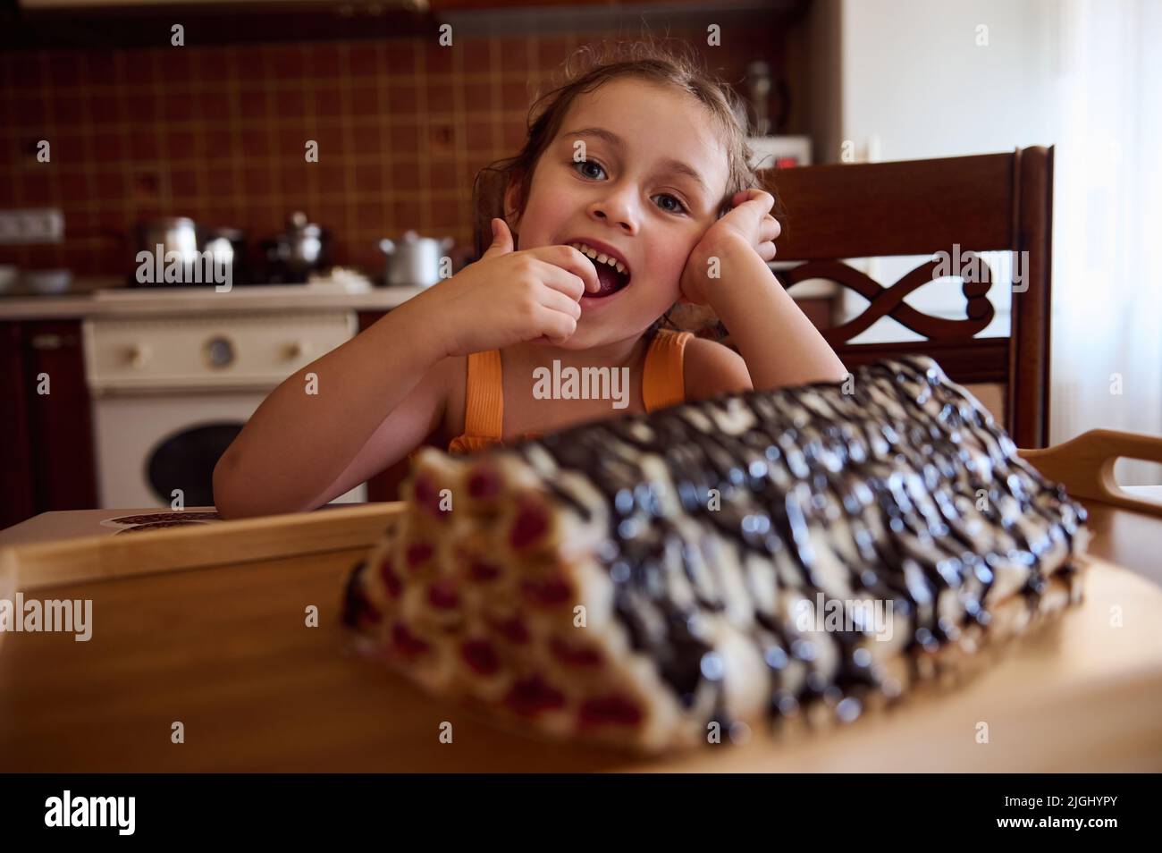 Cheerful Caucasian baby girl sitting a dining table with served ...