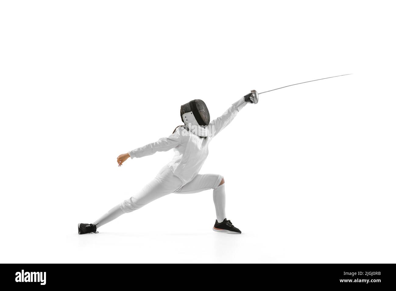 Young girl, beginner fencer in fencing costume and mask practicing with ...