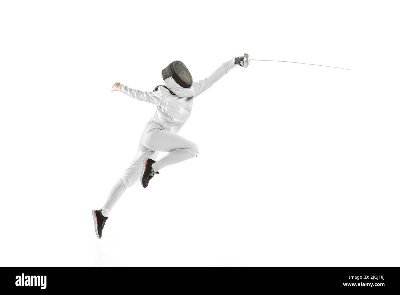 Young girl, beginner fencer in fencing costume and mask practicing with ...