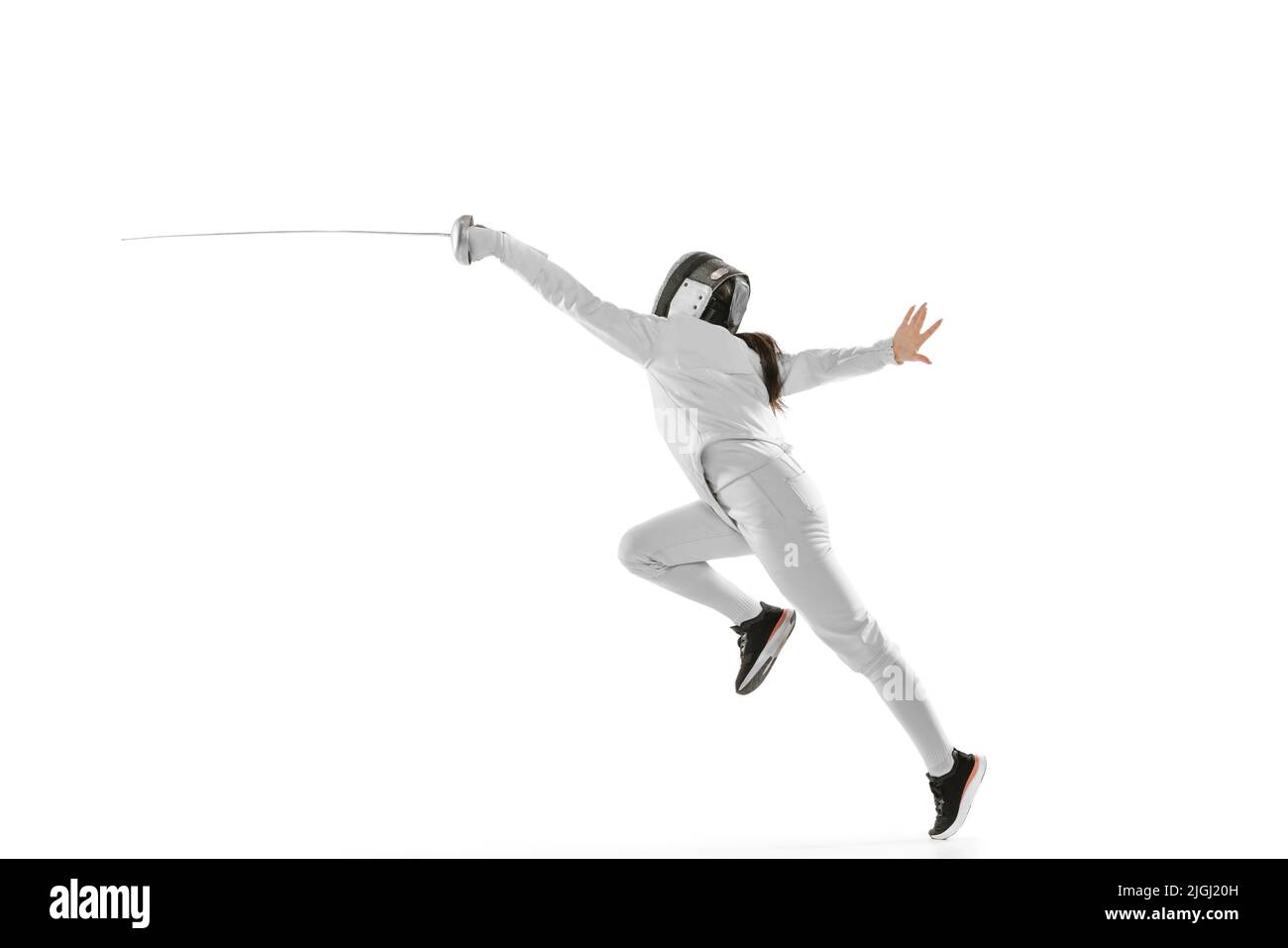 Young girl, beginner fencer in fencing costume and mask practicing with ...