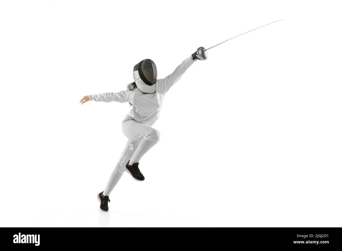 Young girl, beginner fencer in fencing costume and mask practicing with ...