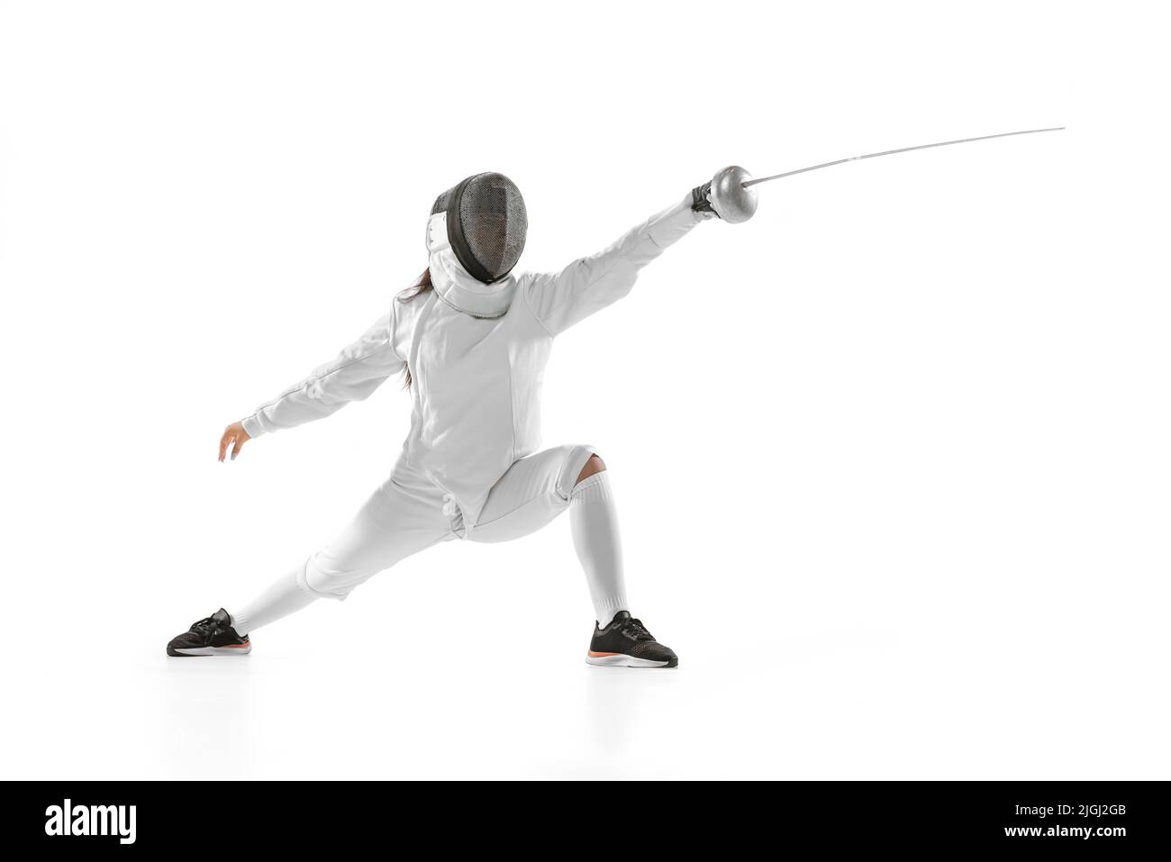 Young girl, beginner fencer in fencing costume and mask practicing with ...