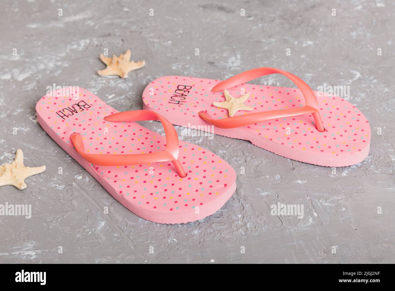 Beach accessories. Flip flops and starfish on colored background. Top ...