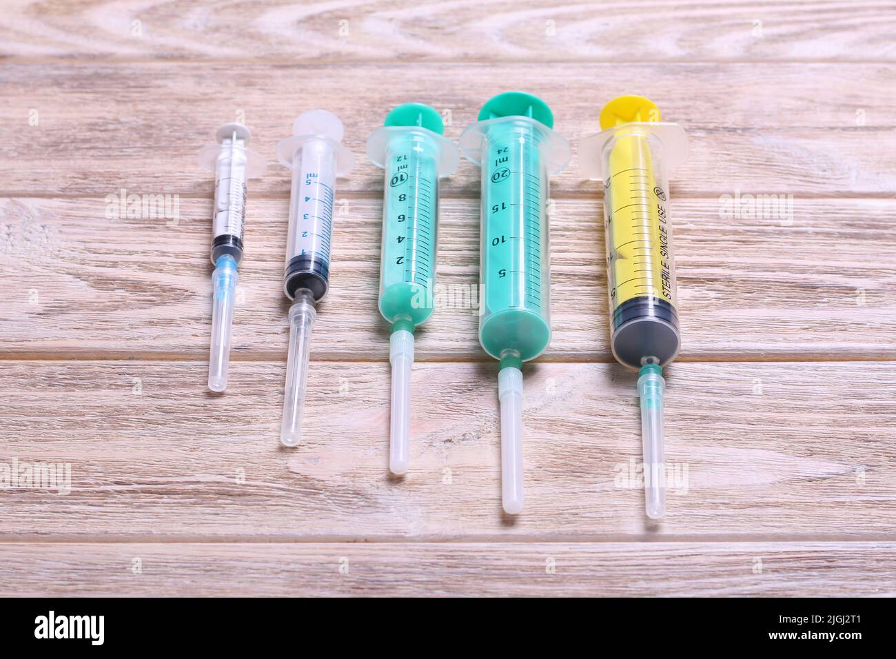 Top view of many syringes prepared for injection at wooden background ...