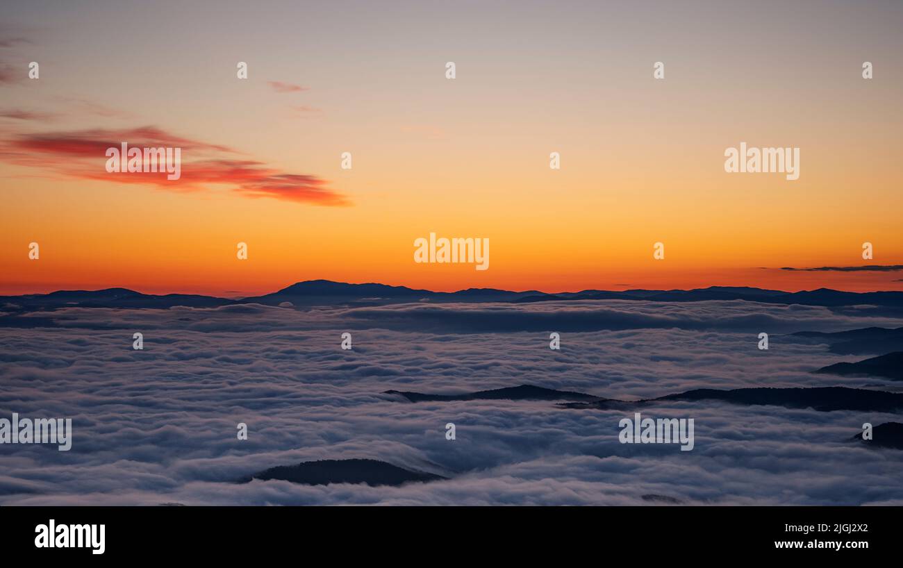 A scenic view of the golden sunset above the clouds Stock Photo - Alamy