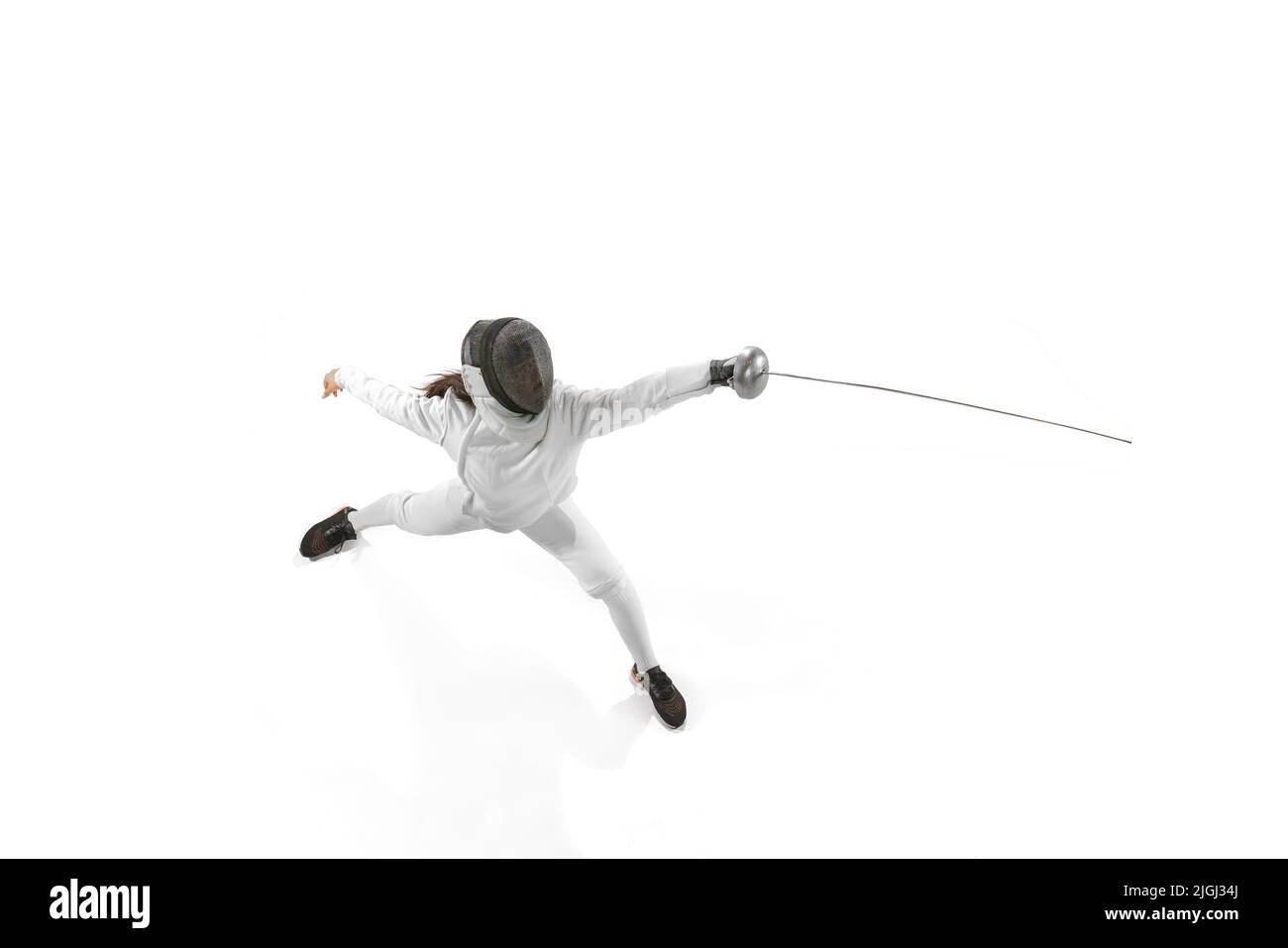 Young girl, beginner fencer in fencing costume and mask practicing with ...