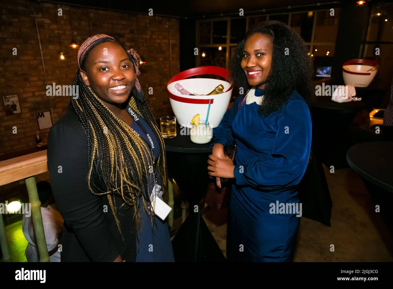 Two African women guests socializing in a sushi restaurant in ...