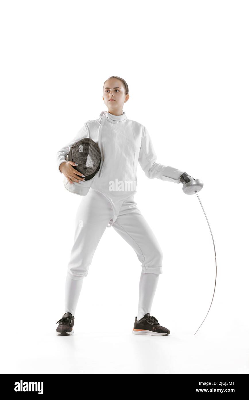 Young girl, fencer in white fencing costume posing with rapier isolated ...