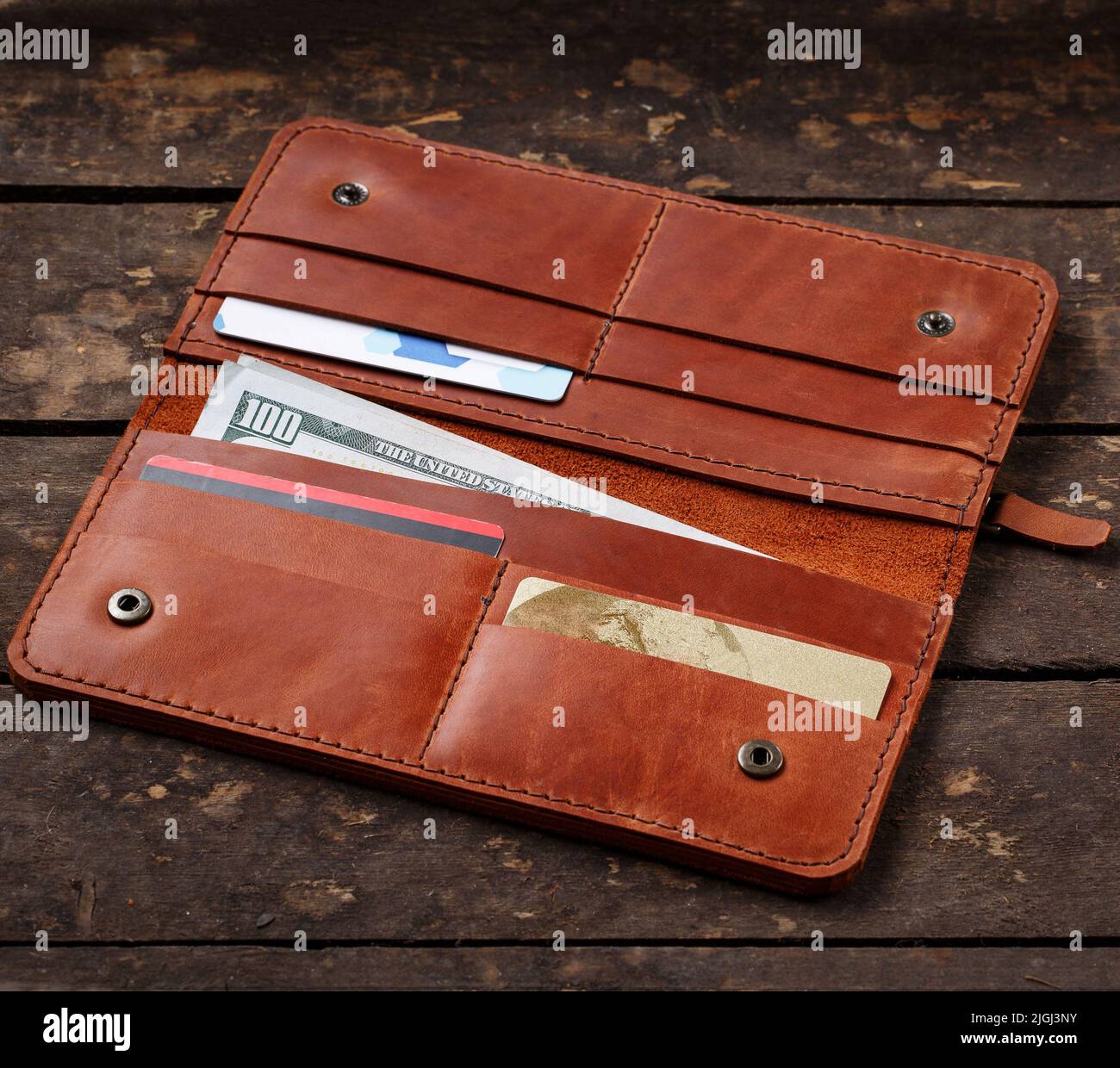Leather red wallet with money and credit cards on old wooden background ...