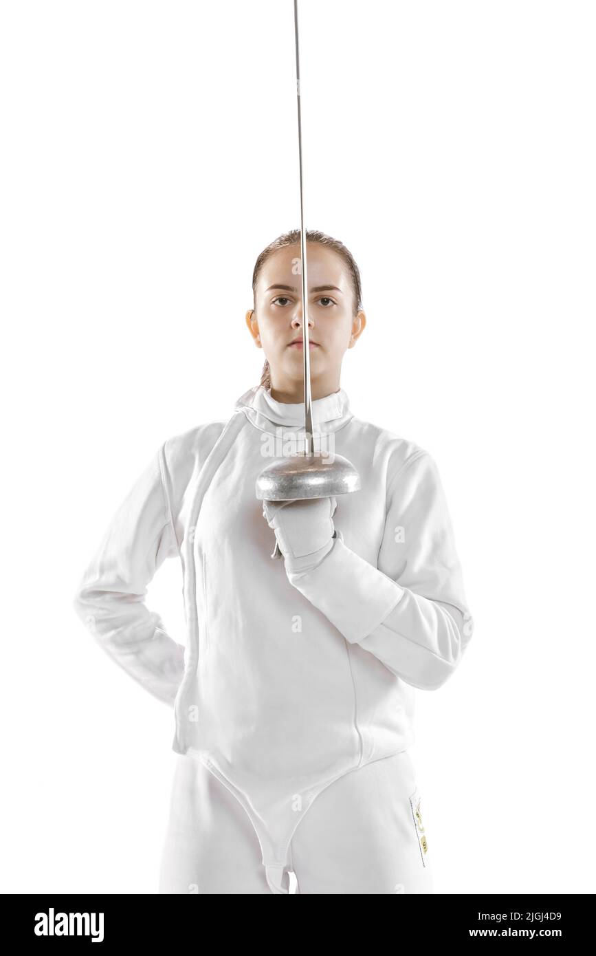 Young girl, fencer in white fencing costume posing with rapier isolated ...