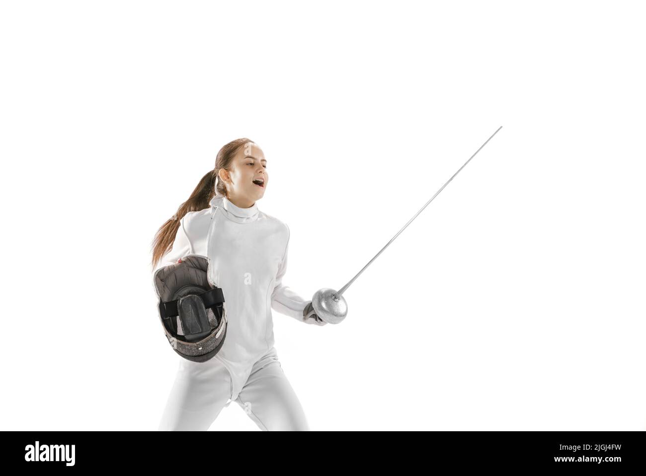 Young girl, fencer in white fencing costume posing with rapier isolated ...
