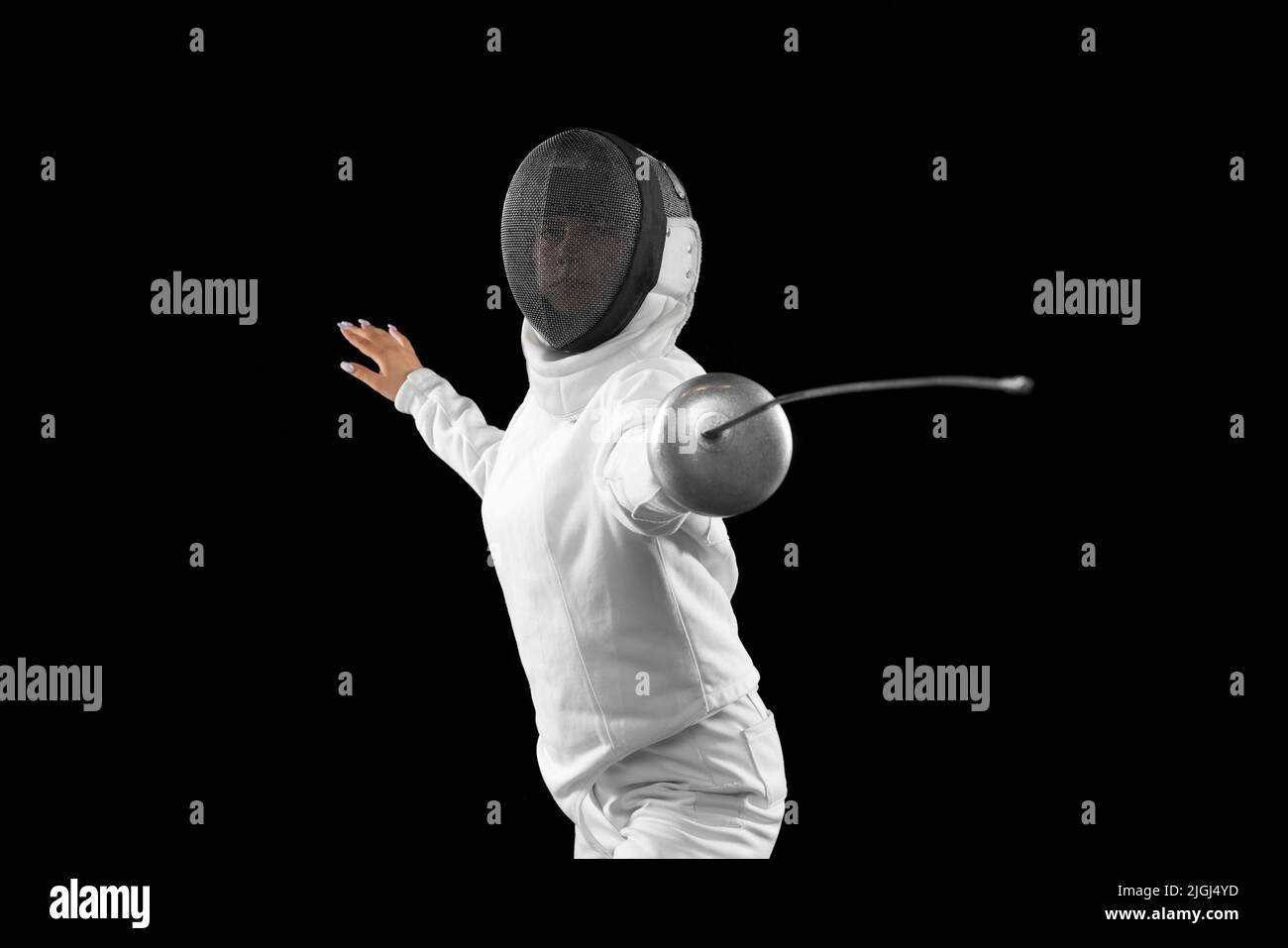 Energetic female fencer in white fencing costume and mask in action ...