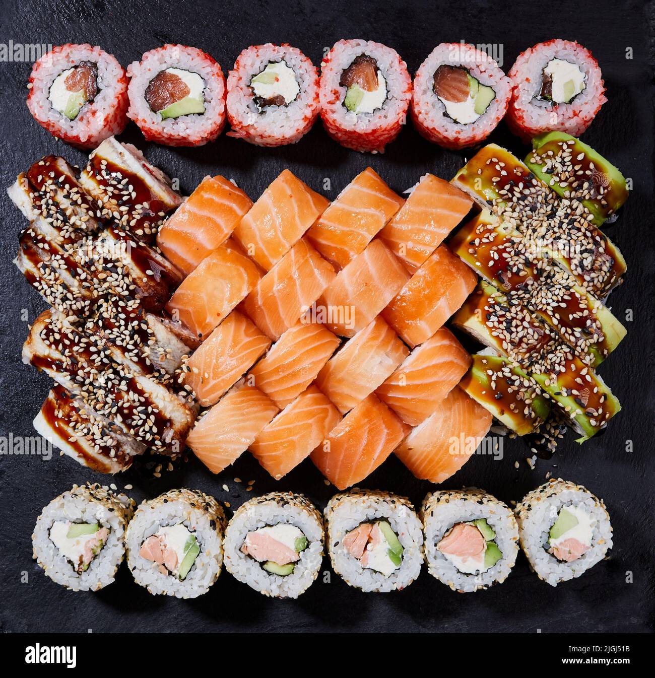 Asian food fest. Close up various kinds of sushi served on a dark ...