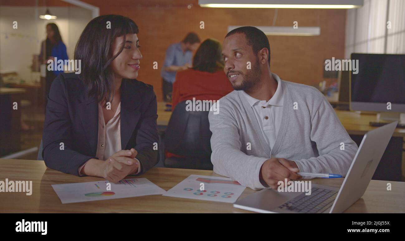 Diverse colleagues discussing work. A black employee explaining new job ...