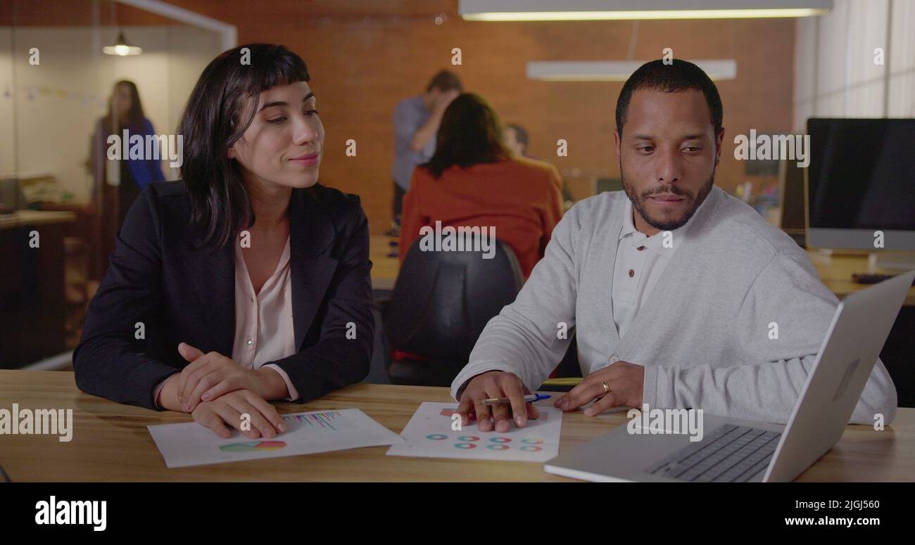 Diverse colleagues discussing work. A black employee explaining new job ...