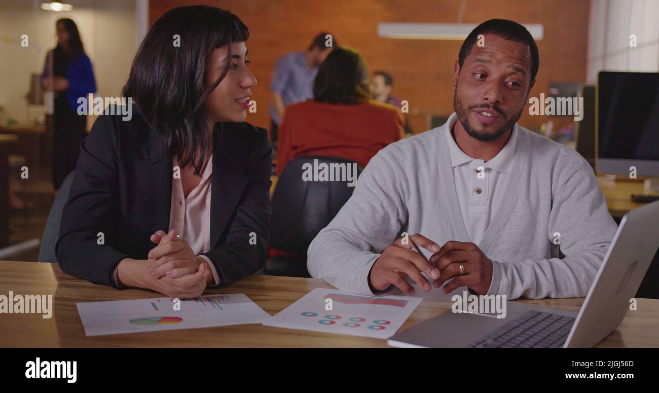 Diverse colleagues discussing work. A black employee explaining new job ...