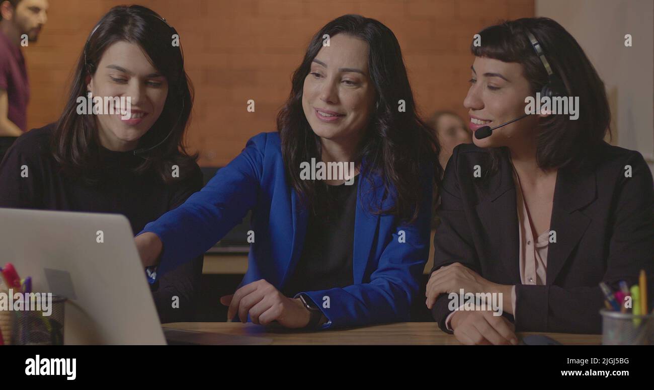Business woman coaching younger staff in front of computer laptop ...