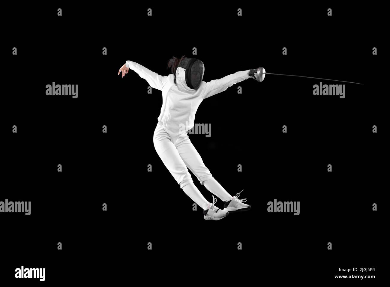 Energetic female fencer in white fencing costume and mask in action ...