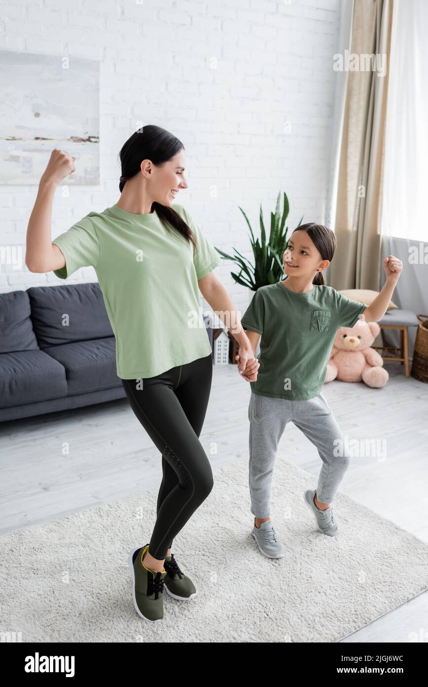 nanny and girl holding hands and smiling at each other while ...