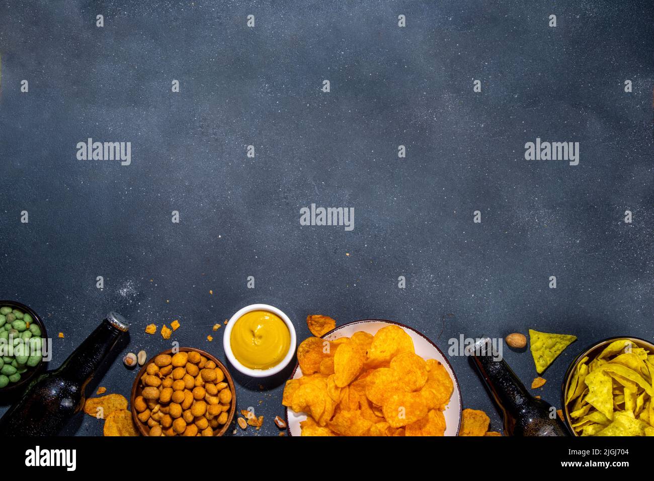 Beer with various salted snacks set. Black table background with ...