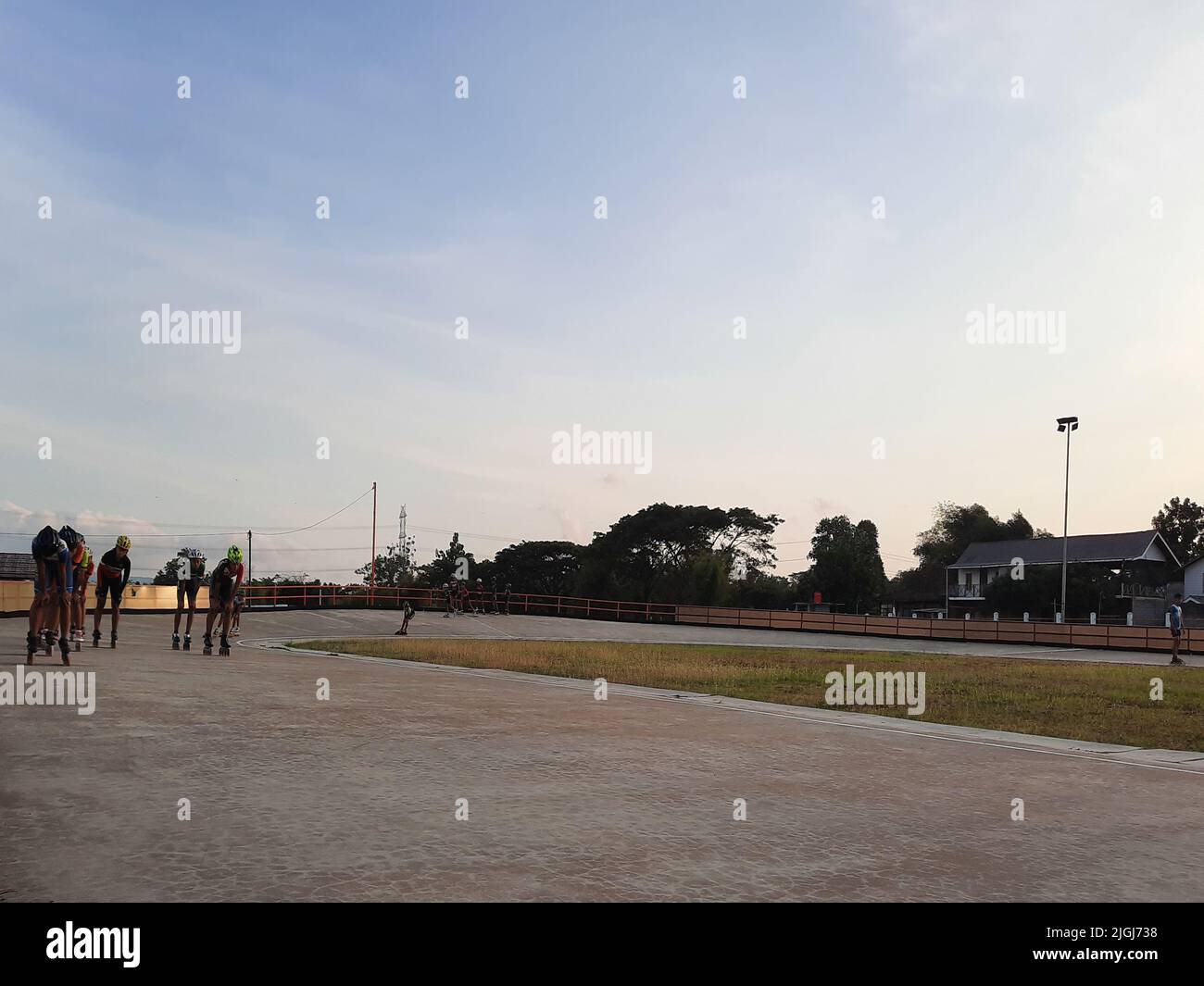 Young mixed Inline scater while training on a track outdoors at stadion ...