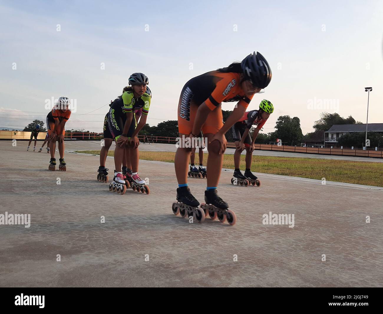 Young mixed Inline scater while training on a track outdoors at stadion ...
