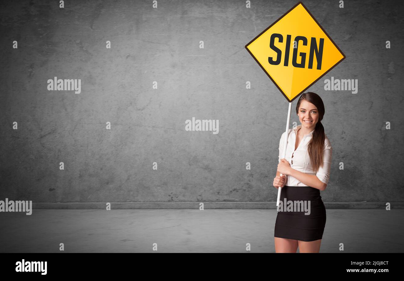Young business person holding road sign Stock Photo - Alamy