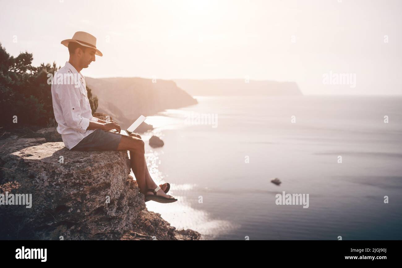 Digital nomad, freelancer. Remote work on vacation. Man in the hat, a ...