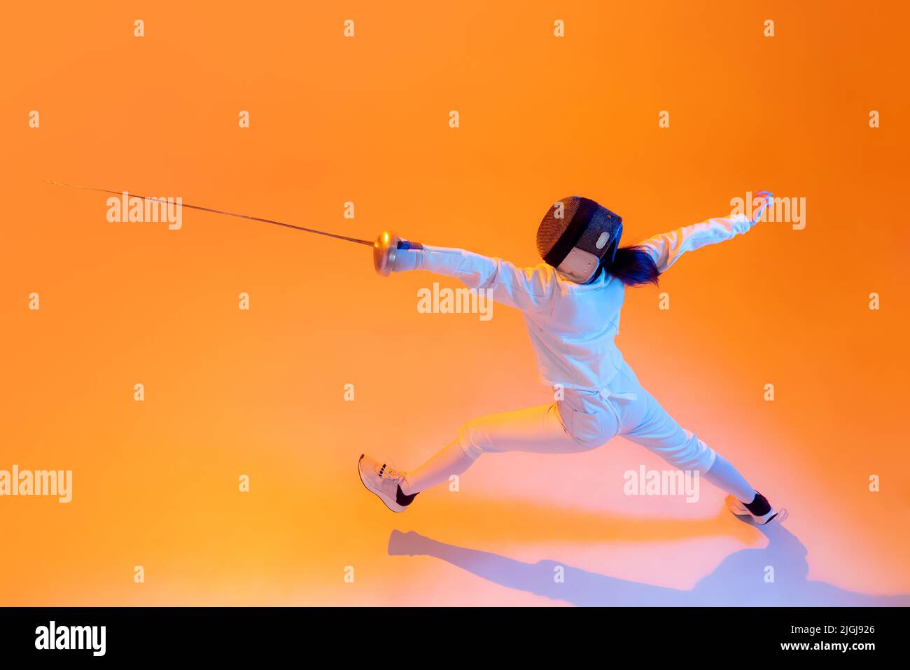 Aerial view of professional fencer in white fencing costume and mask in ...
