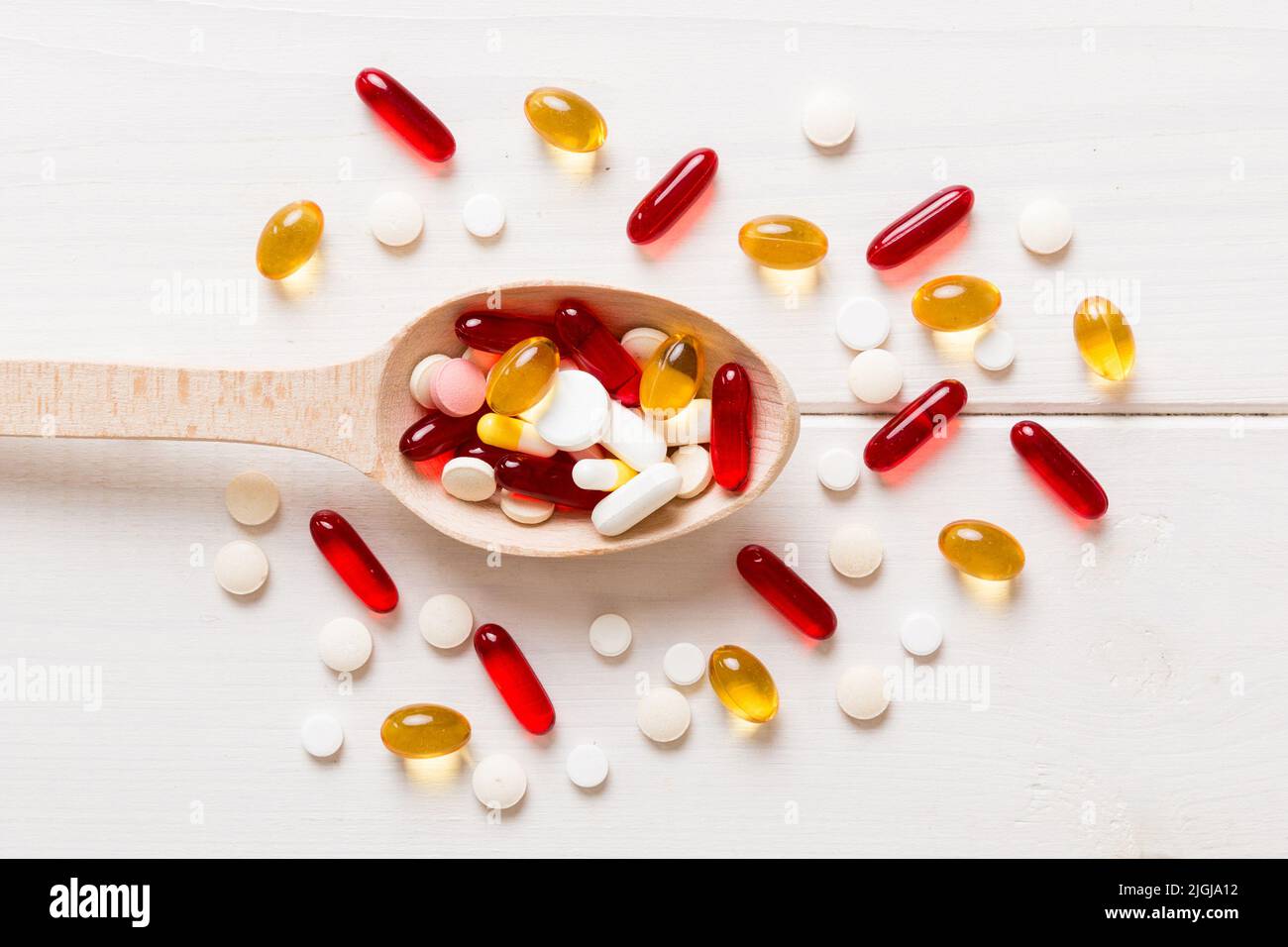 Vitamin capsules in a spoon on a colored background. Pills served as a ...