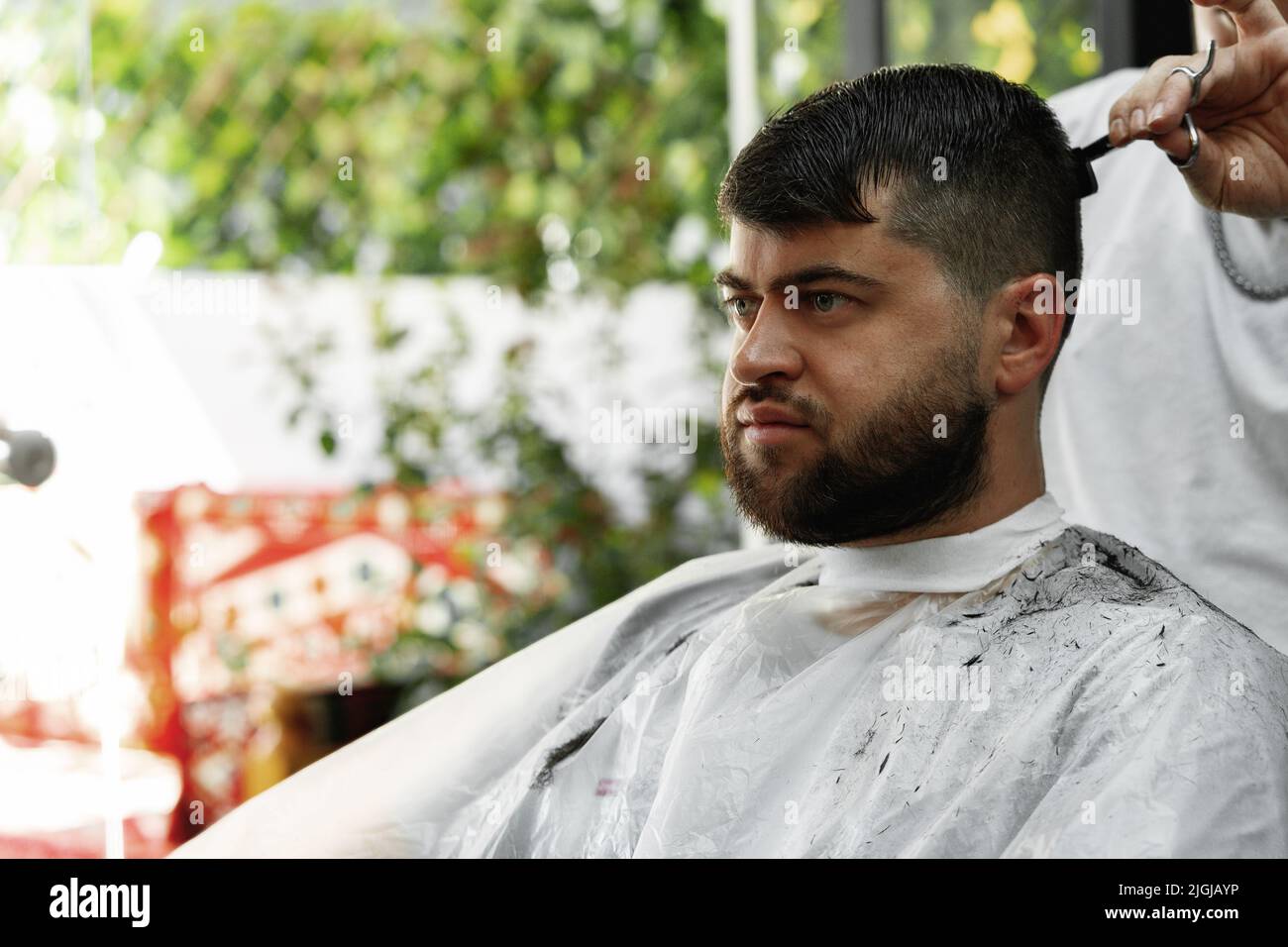 Male client getting haircut by hairdresser in barbershop Stock Photo ...