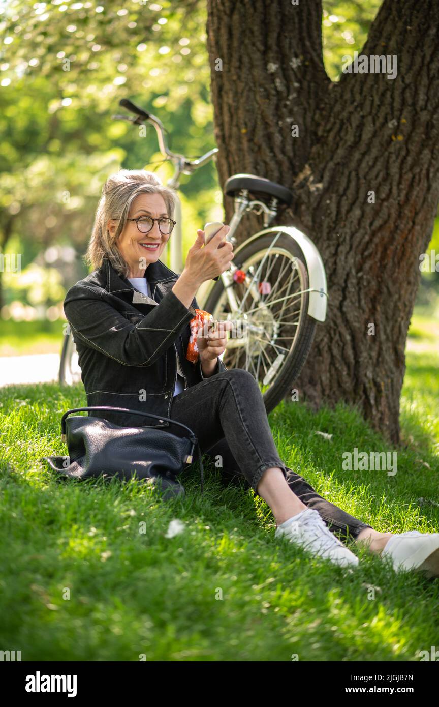 A mature woman in eyeglasses doing make up Stock Photo - Alamy