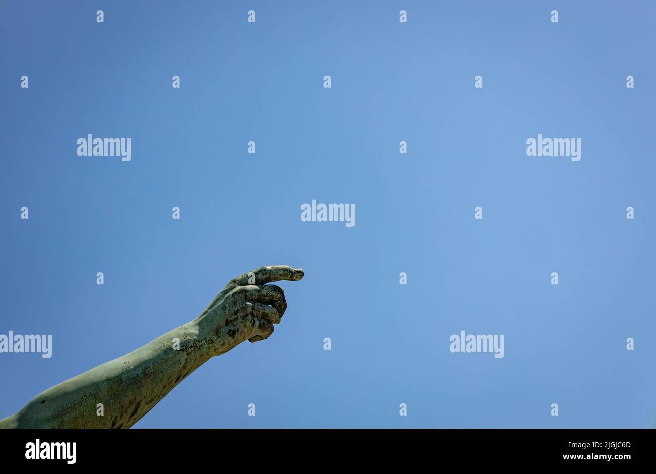 Metallic hand of an ancient sculpture pointing to the sky. Concept of ...