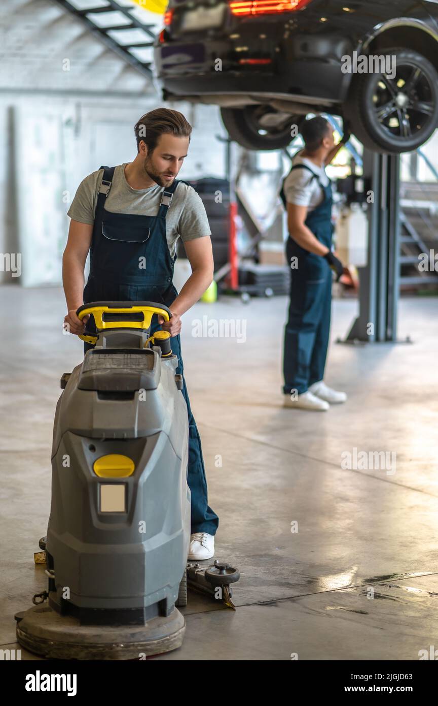 Technicians working in a auto repair shop and looking busy Stock Photo ...