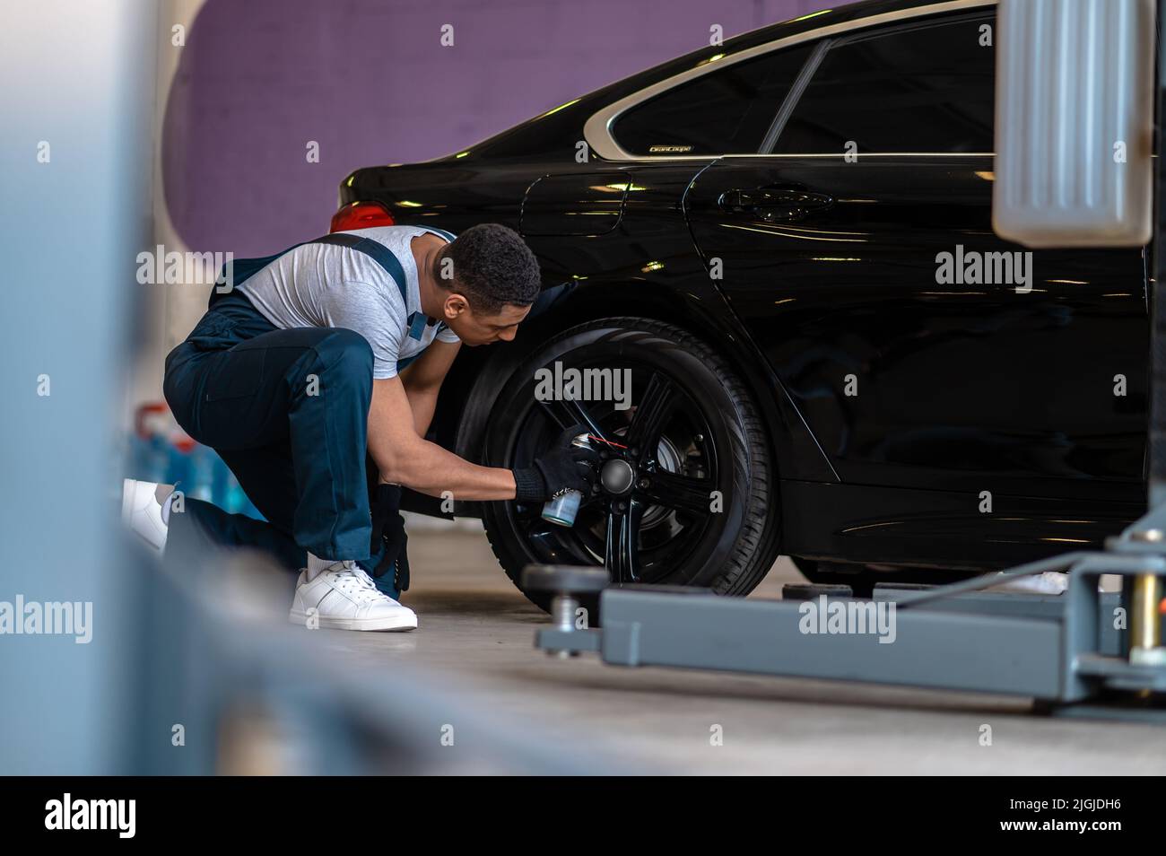 Auto repair worker checking the wheel of the car Stock Photo - Alamy