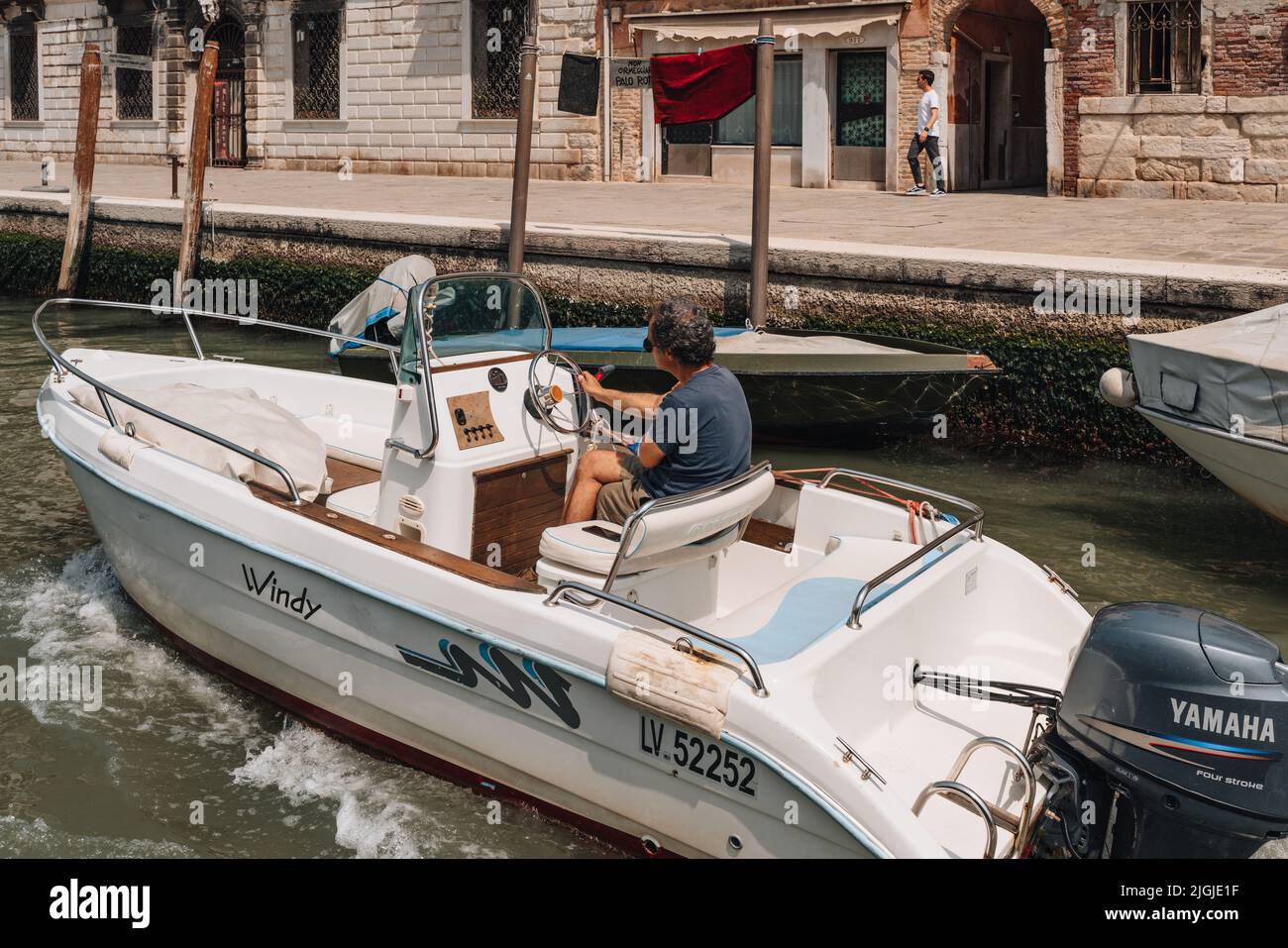 Venice, Italy - May 22, 2022: High angle view of a man navigating a oat ...