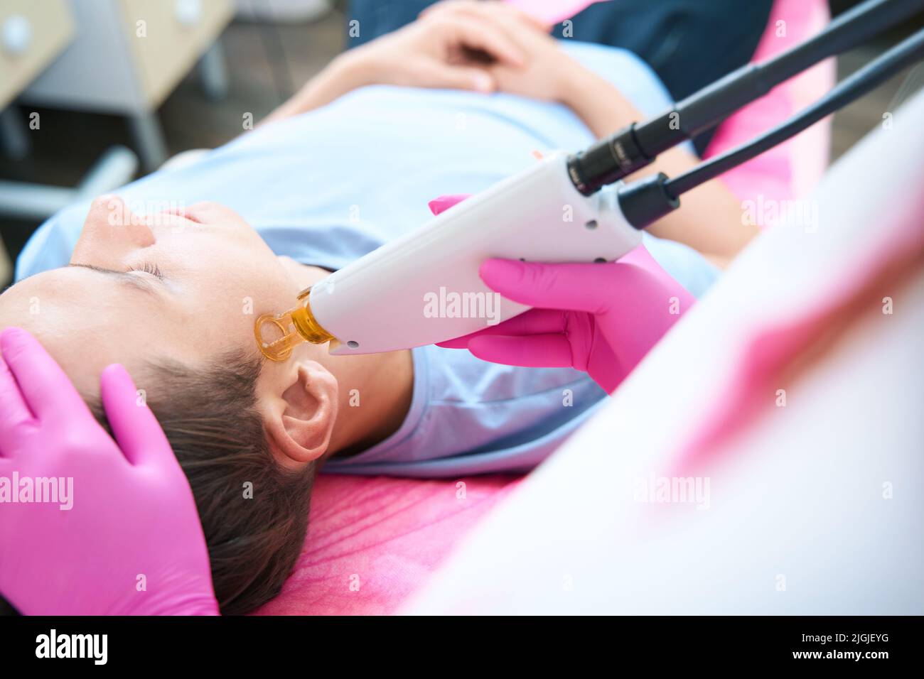Beautician doing laser epilation for male client Stock Photo - Alamy