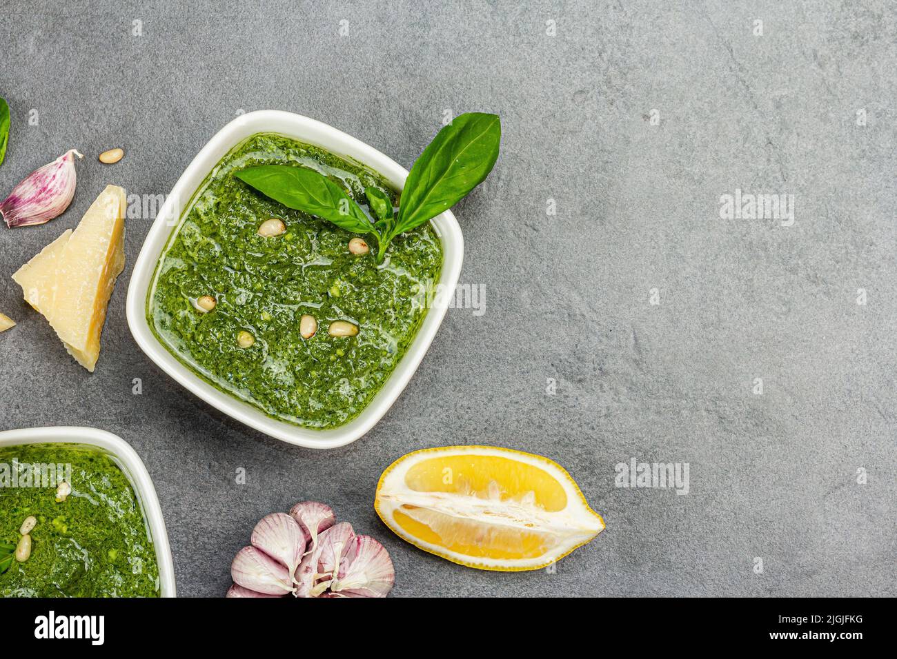 Pesto sauce in a bowls with pine nuts, parmesan and garlic. Traditional ...