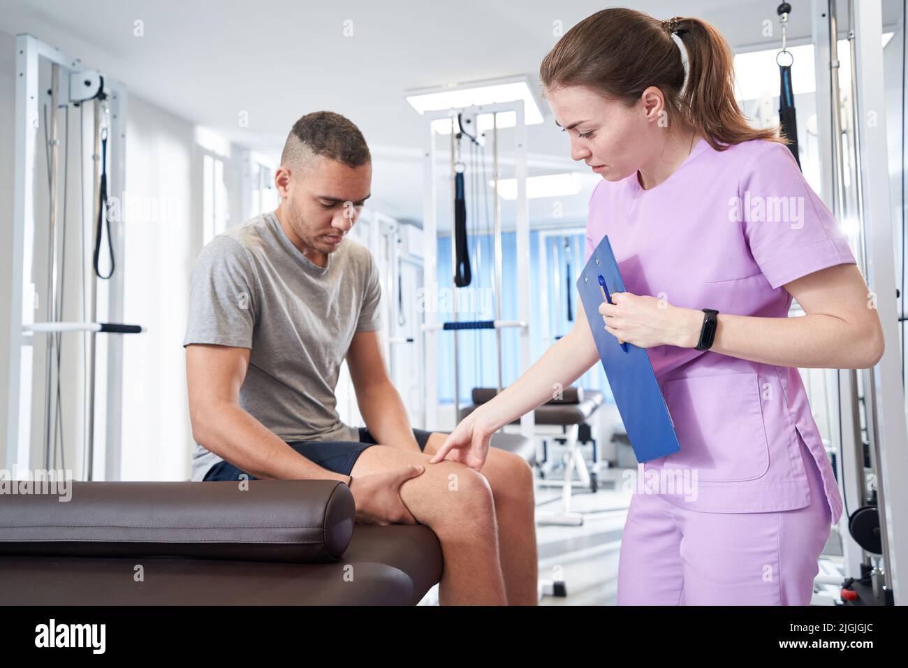 Woman doctor examining male patient leg in clinic Stock Photo - Alamy