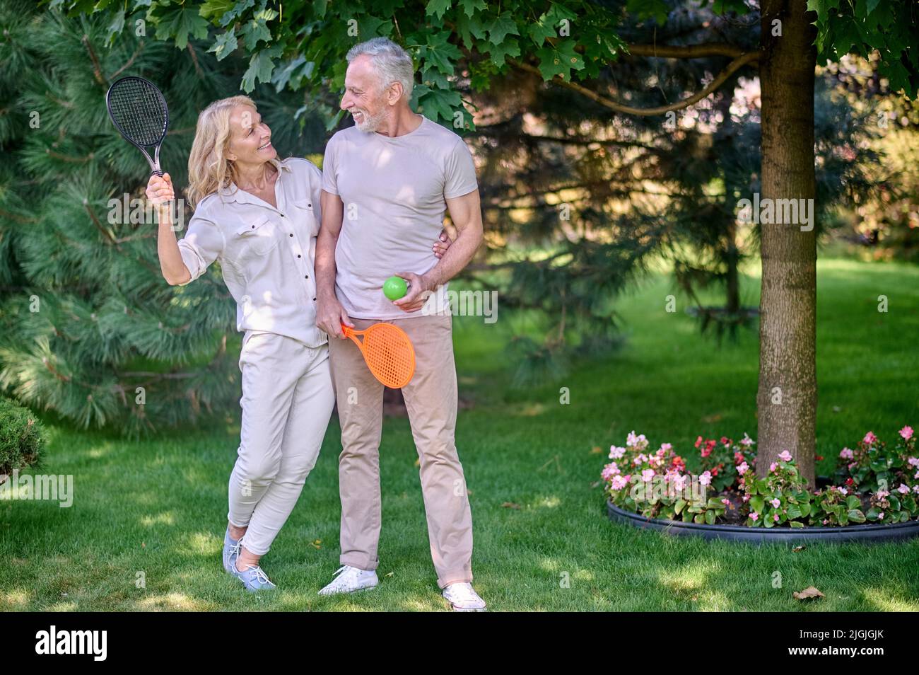 Mature mand and woman with rackets looking enjoyed and happy Stock ...