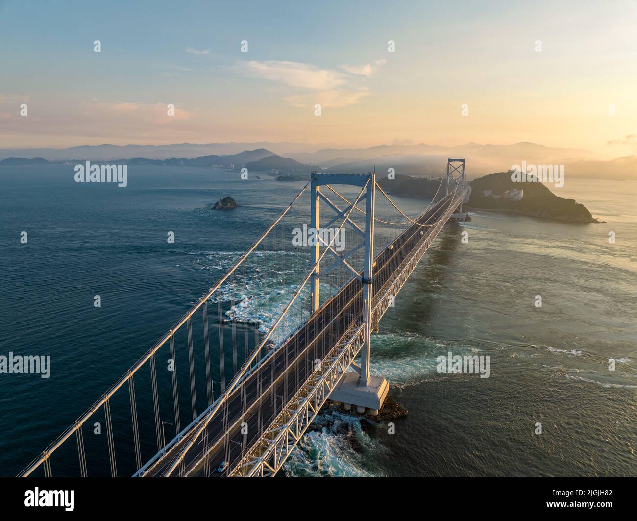 Overhead view of span with light traffic on suspension bridge at sunset ...